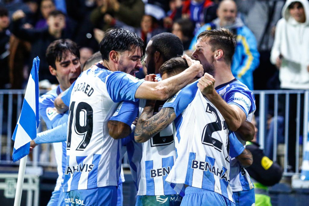 Malaga fans gather at airport to welcome back play-off heroes